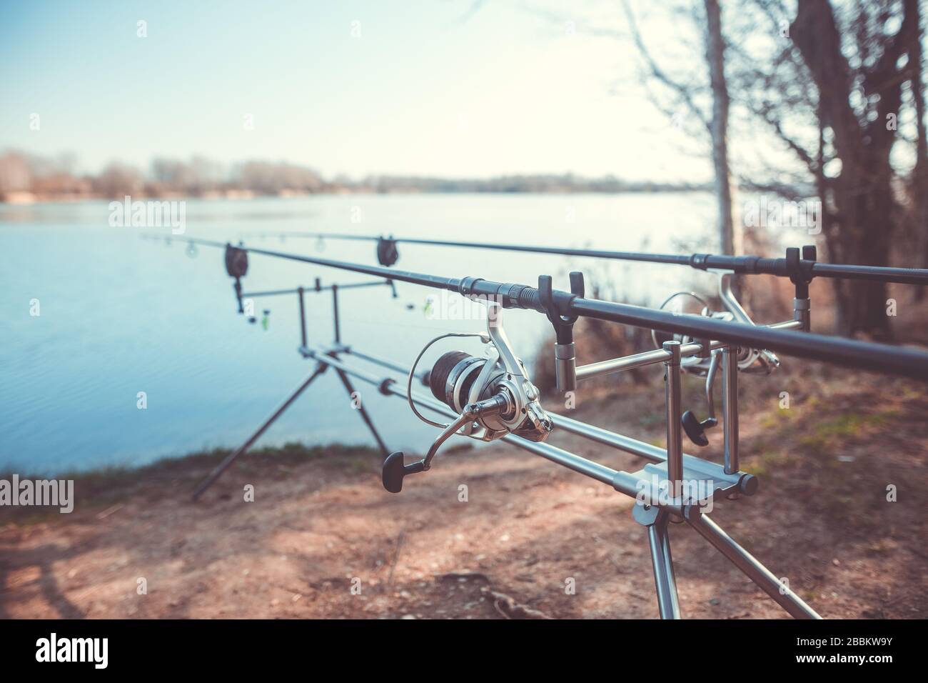 Two cast fishing rods on the rack by the lake, ready for fishing ...
