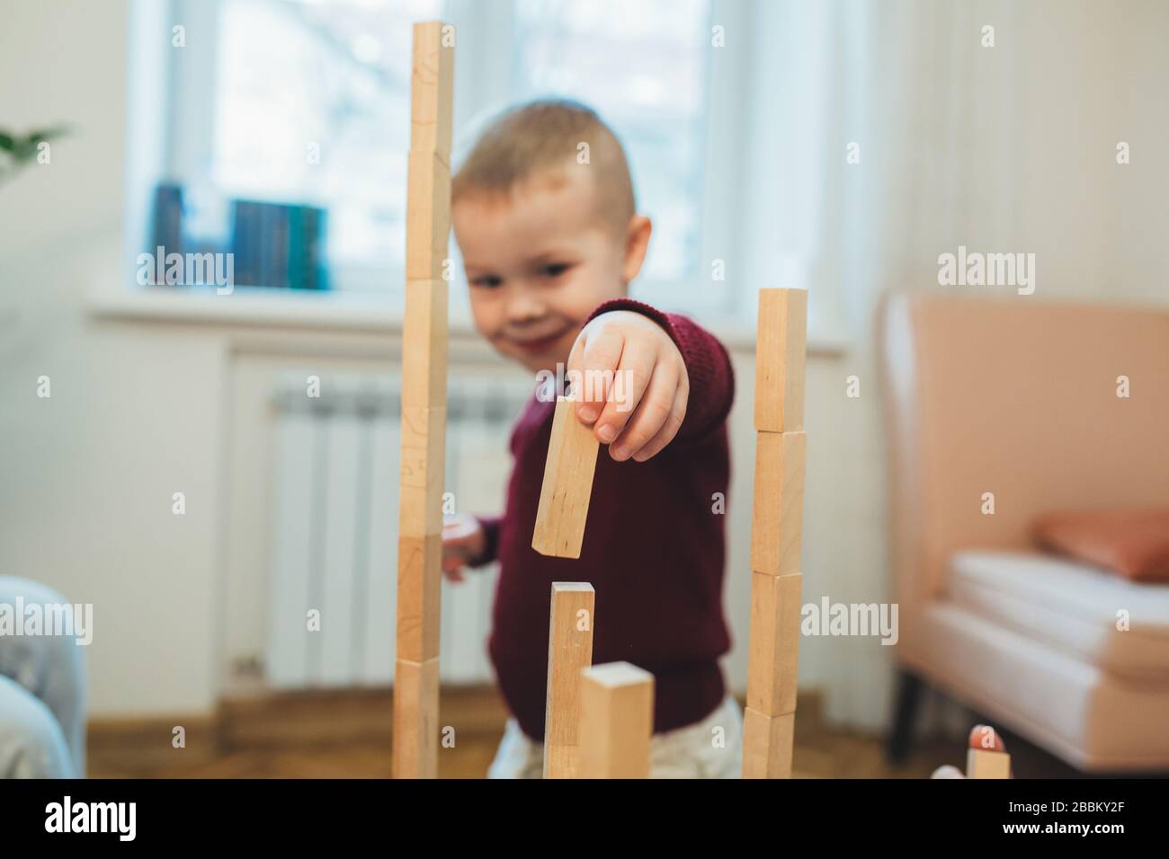 Small caucasian boy building something with wooden constructor playing ...