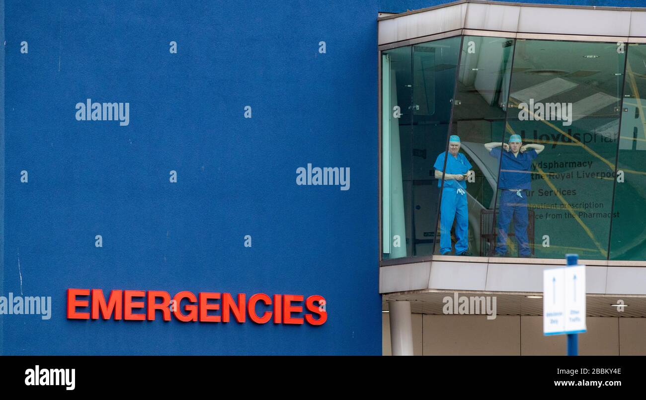 Two medical personnel look out of the window of the Royal Liverpool ...
