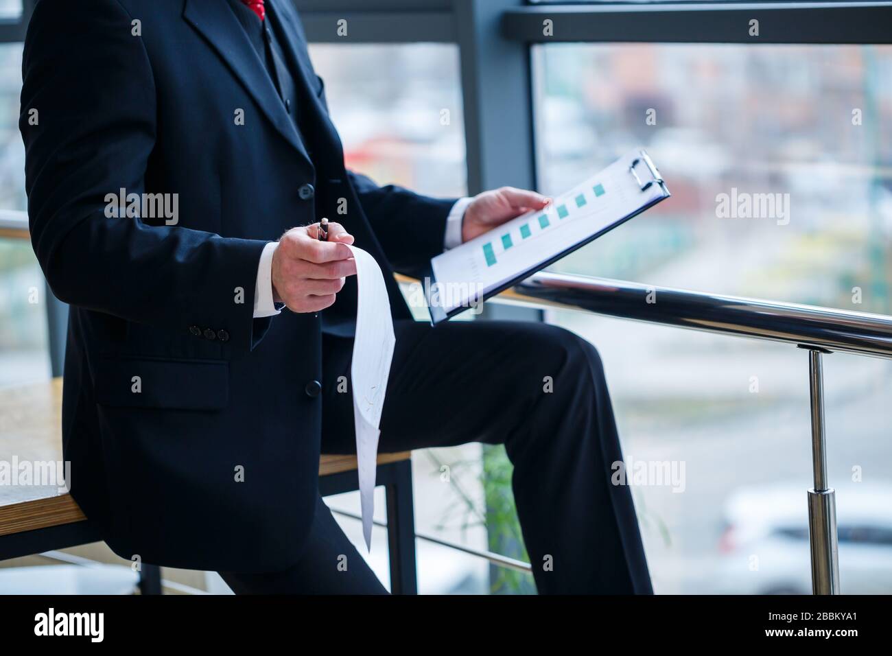 Man managing director leaned on a wooden table in his office near a ...