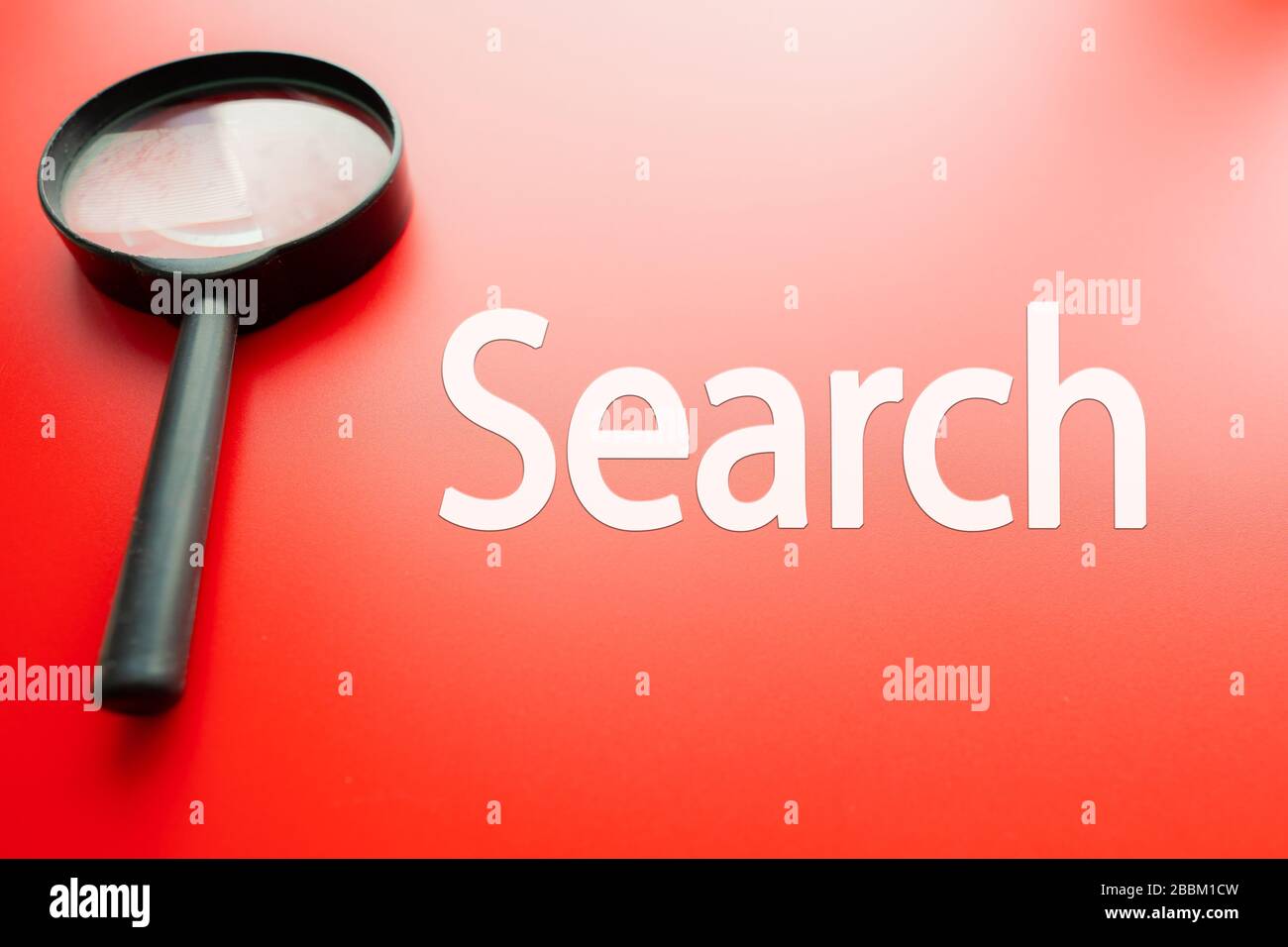 Word search written on red background and magnifying glass next to it ...