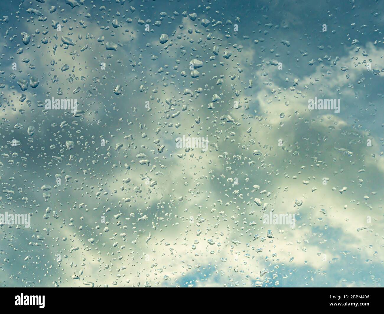 Wet window with rain drops and a cloudy sky outside background Stock ...
