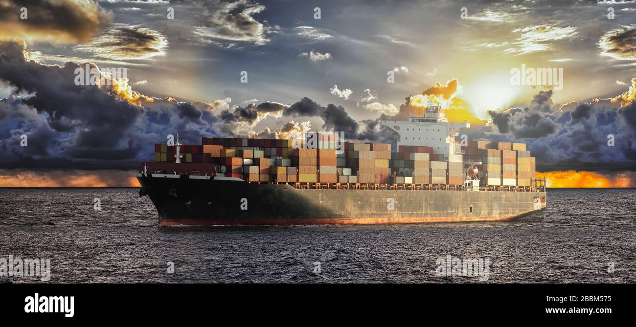 Mighty container ships in ocean at sunrise underway performing import and export marine cargo ...