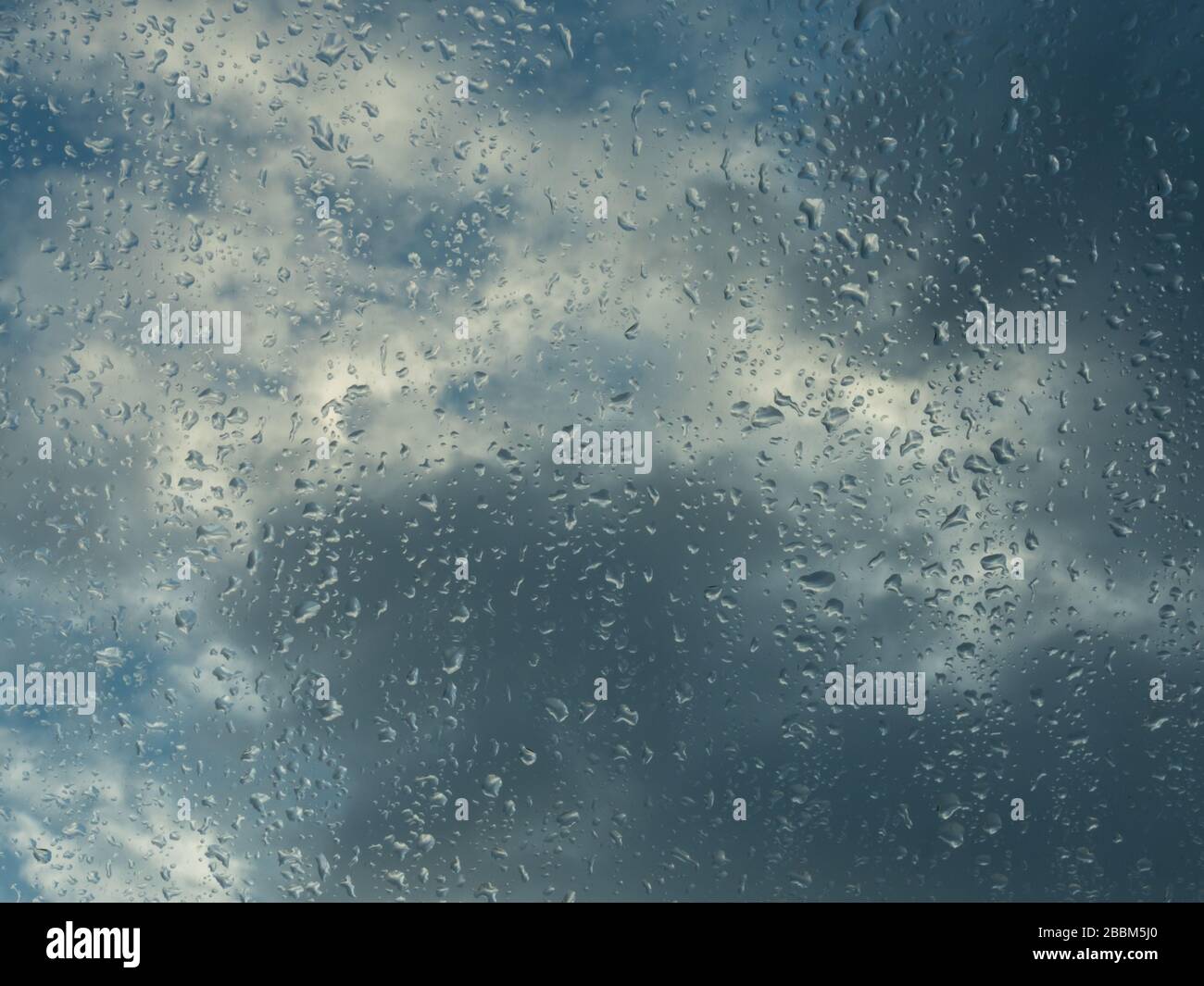 Wet window with rain drops and a cloudy sky outside background Stock ...