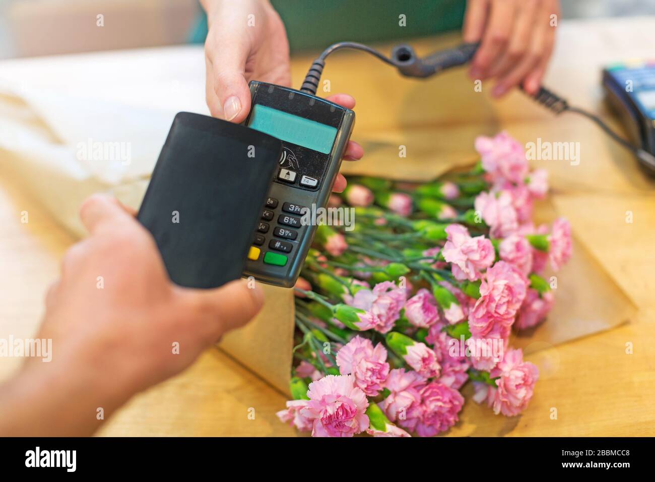 Customer paying in flower shop Stock Photo - Alamy