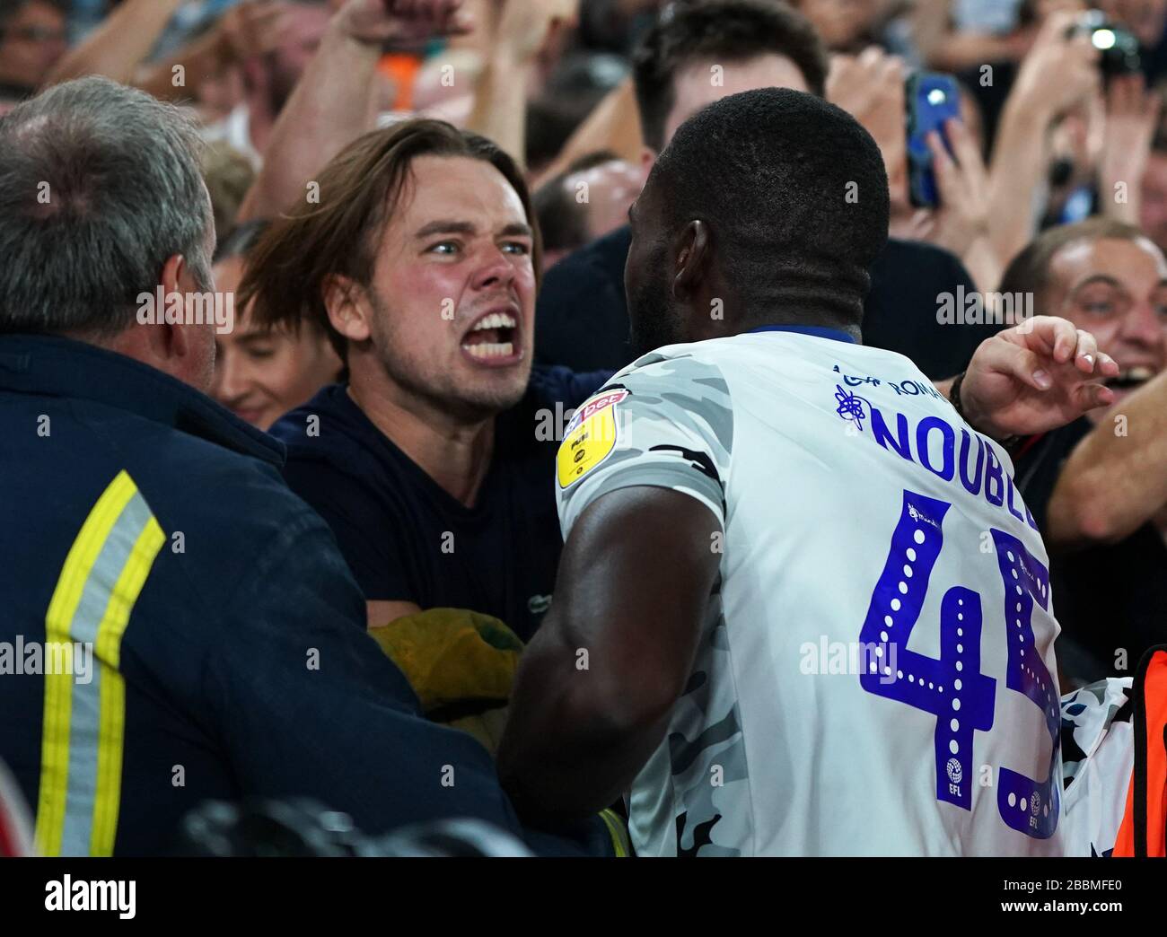A Colchester United fan celebrates winning the tie with Frank Nouble ...