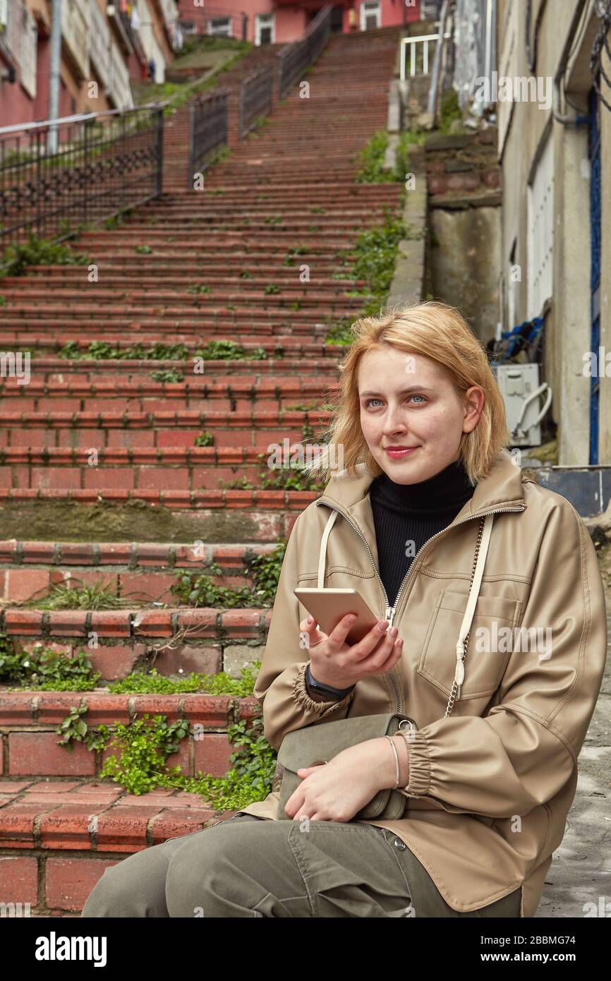 A young Caucasian woman walks alone in deserted Istanbul in winter, she ...