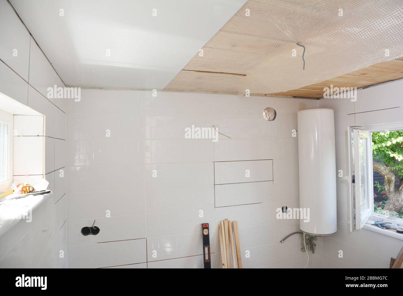 Installing white PVC Ceiling Boards in the new bathroom Stock Photo - Alamy