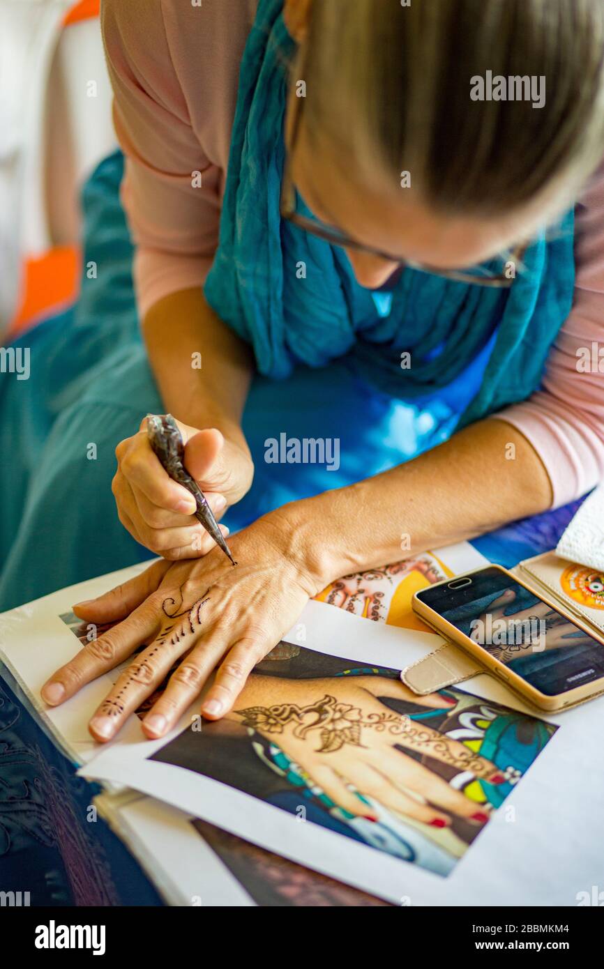 Henna paint tattoo in progress Stock Photo - Alamy