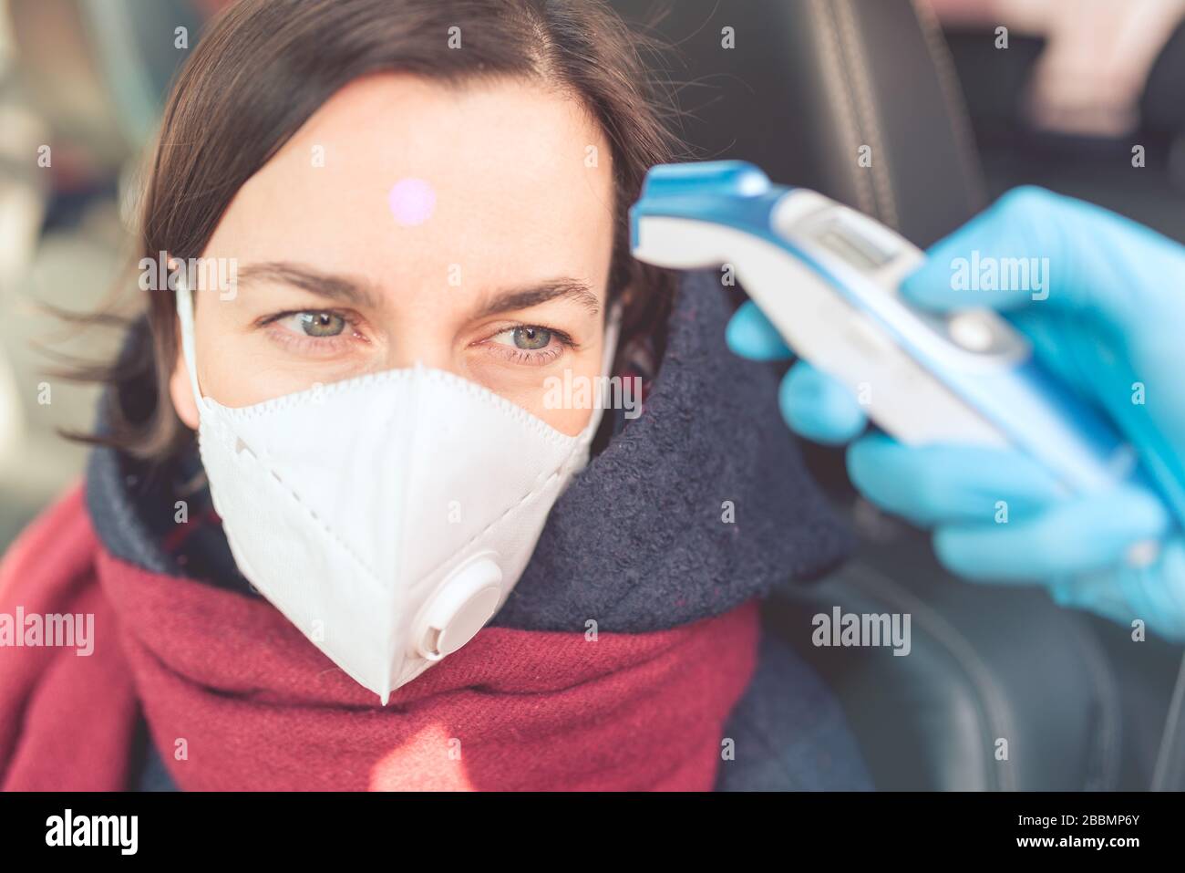Temperature check point - the woman behind the wheel of the car in an ...