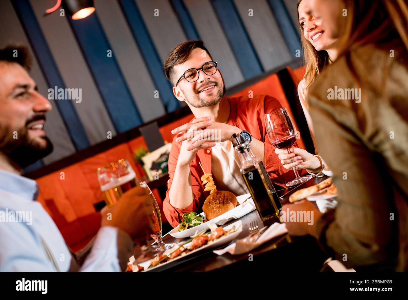 Group of young people having dinner in the restaurant Stock Photo - Alamy