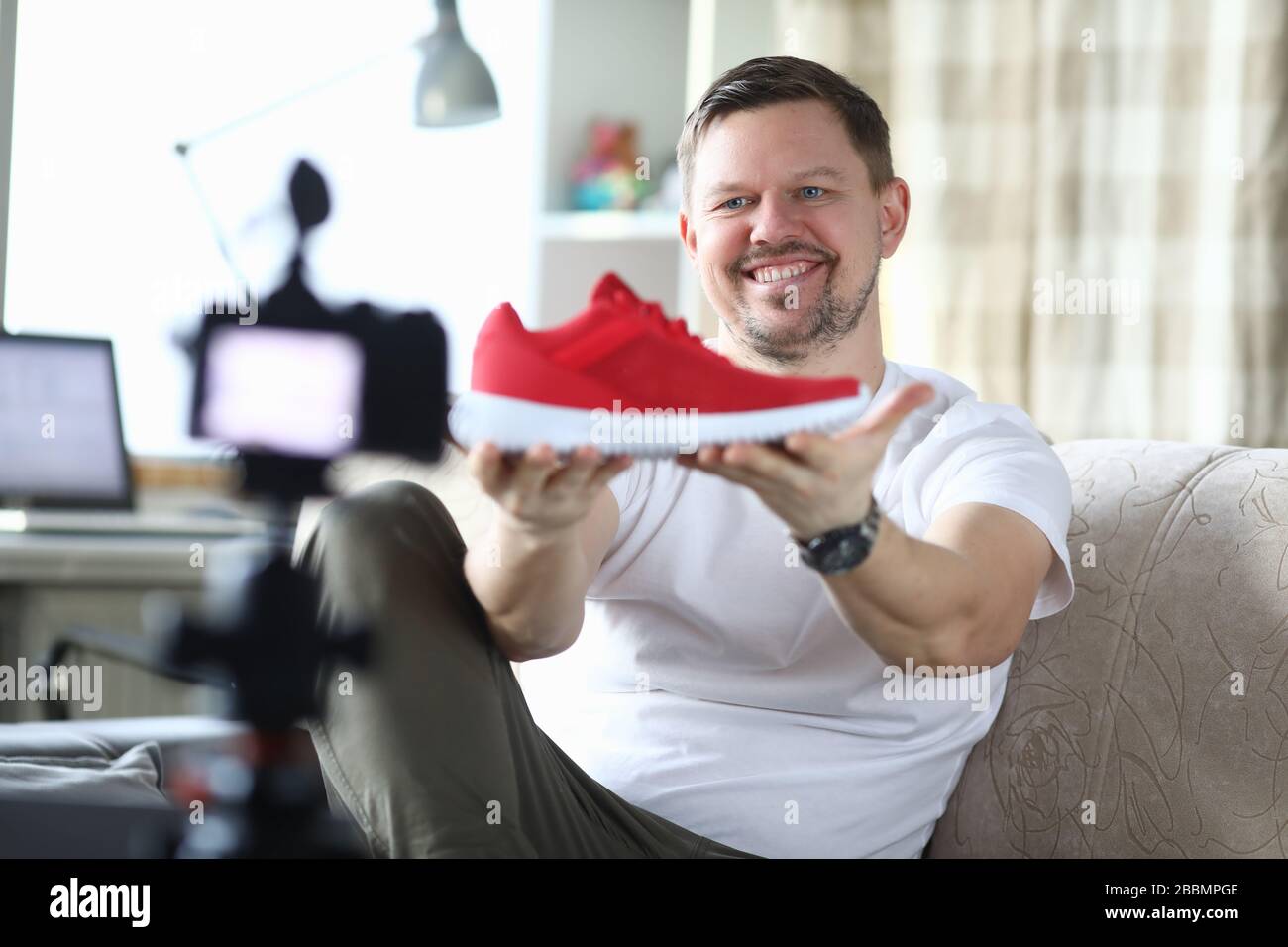 Man in an apartment is filming review new sneakers Stock Photo - Alamy