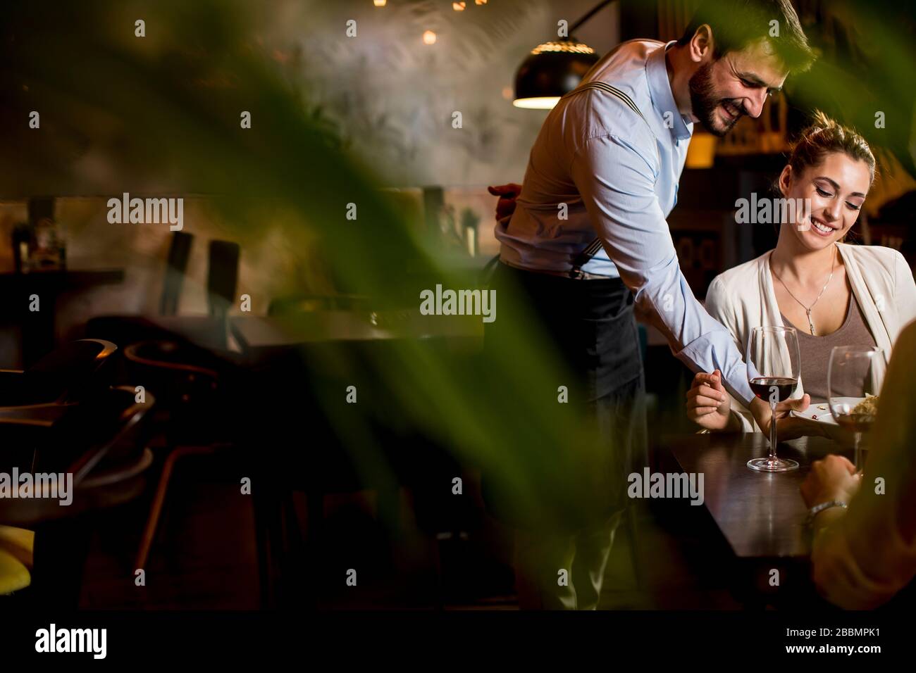 Smiling waiter serving dinner hi-res stock photography and images - Alamy