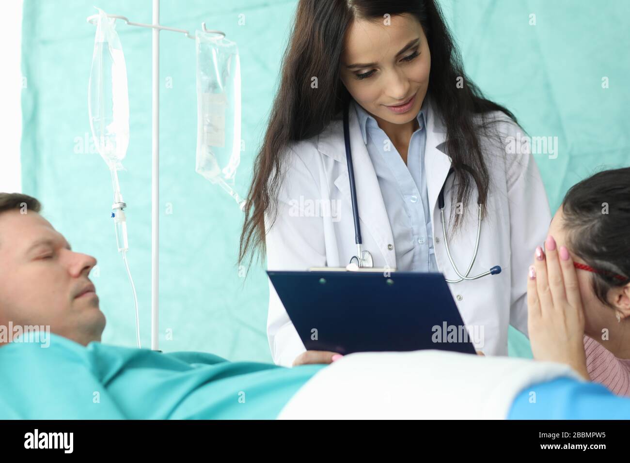 Female doctor shows analyzes sick man to his wife Stock Photo - Alamy