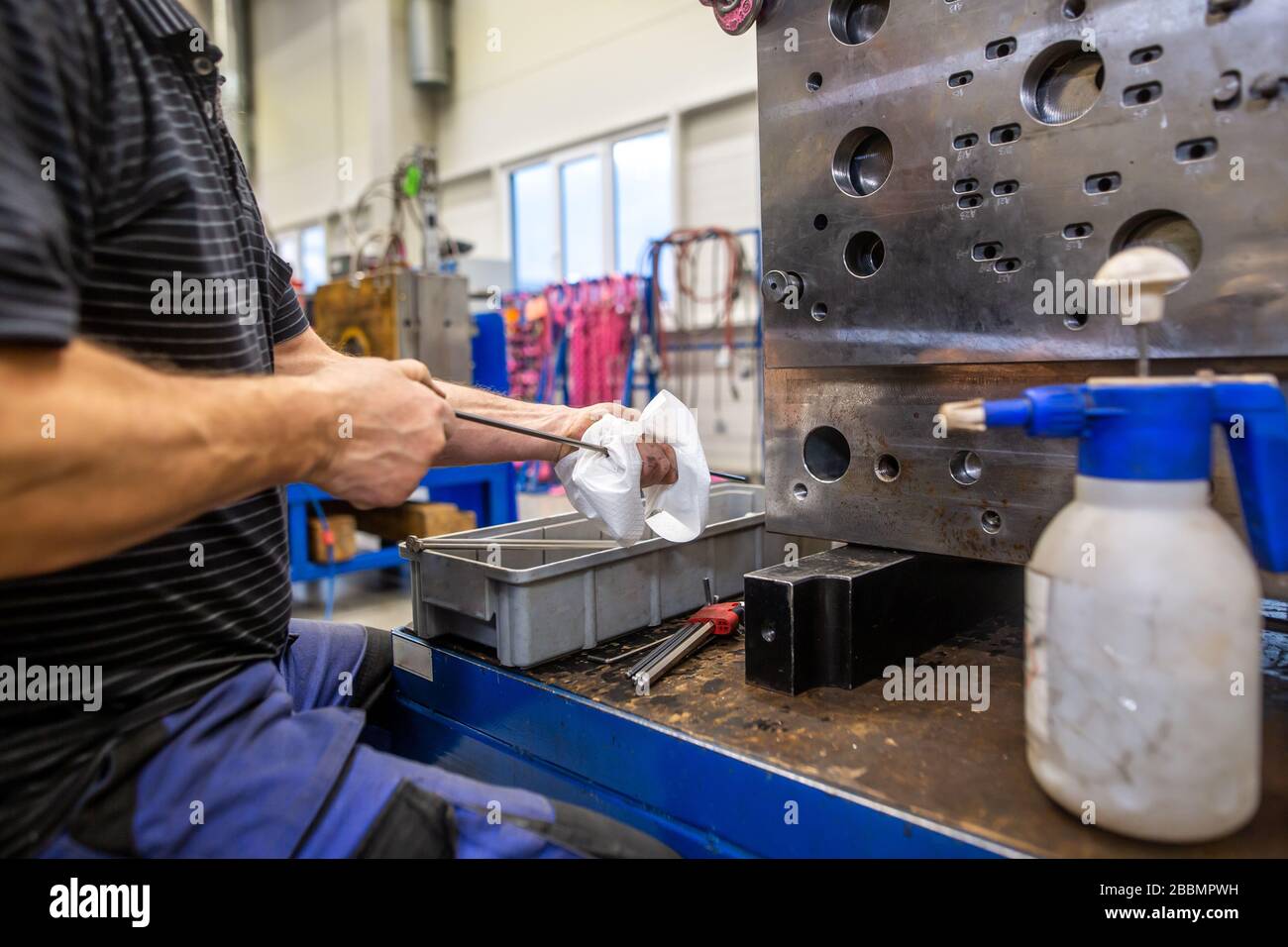Engineer doing maintenance on the injection mold after production ...