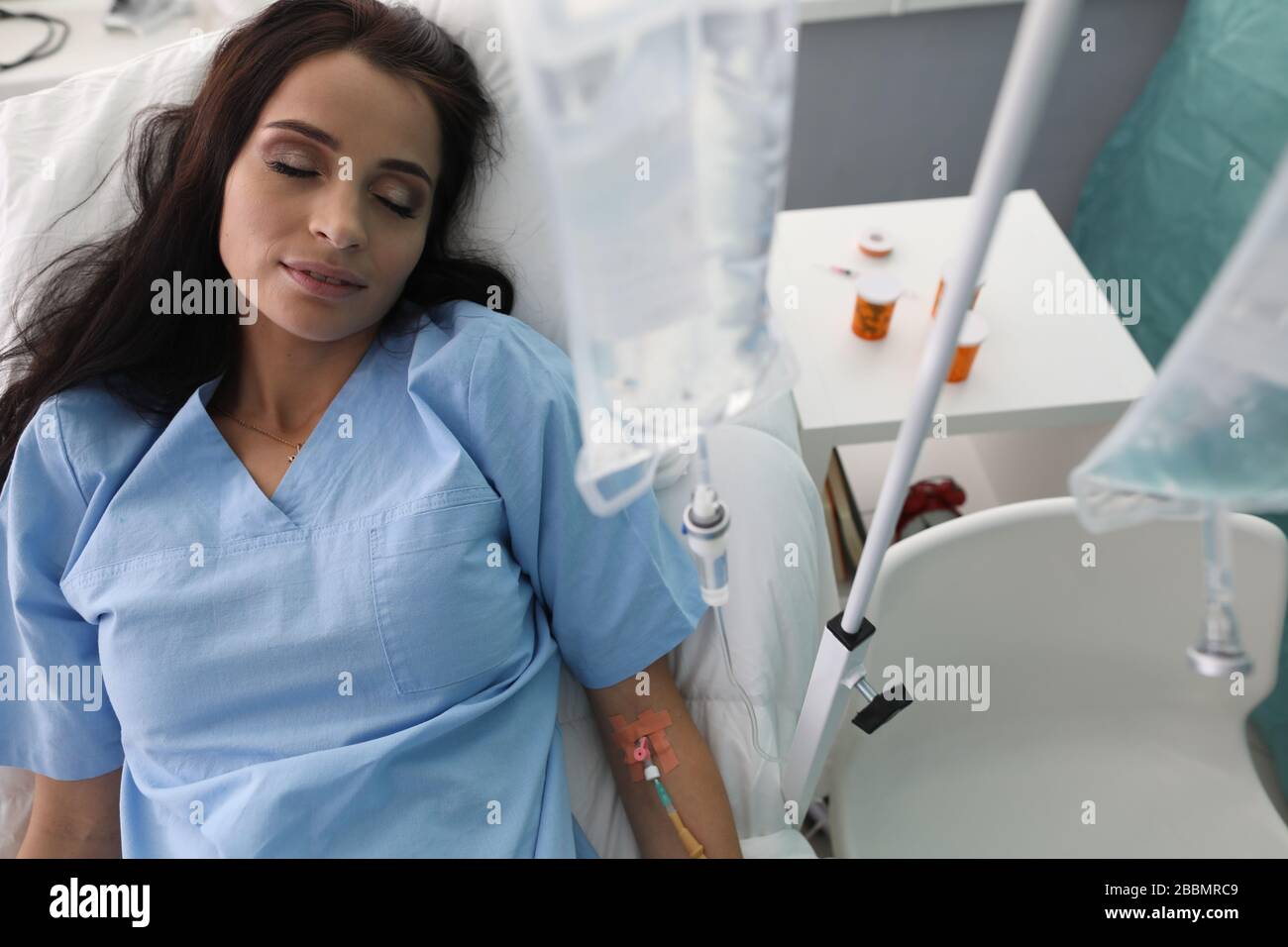 Beautiful girl sleeps in clinic under drug dropper Stock Photo - Alamy