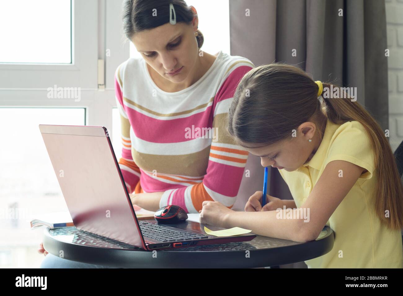 Mom helps daughter do homework Stock Photo - Alamy