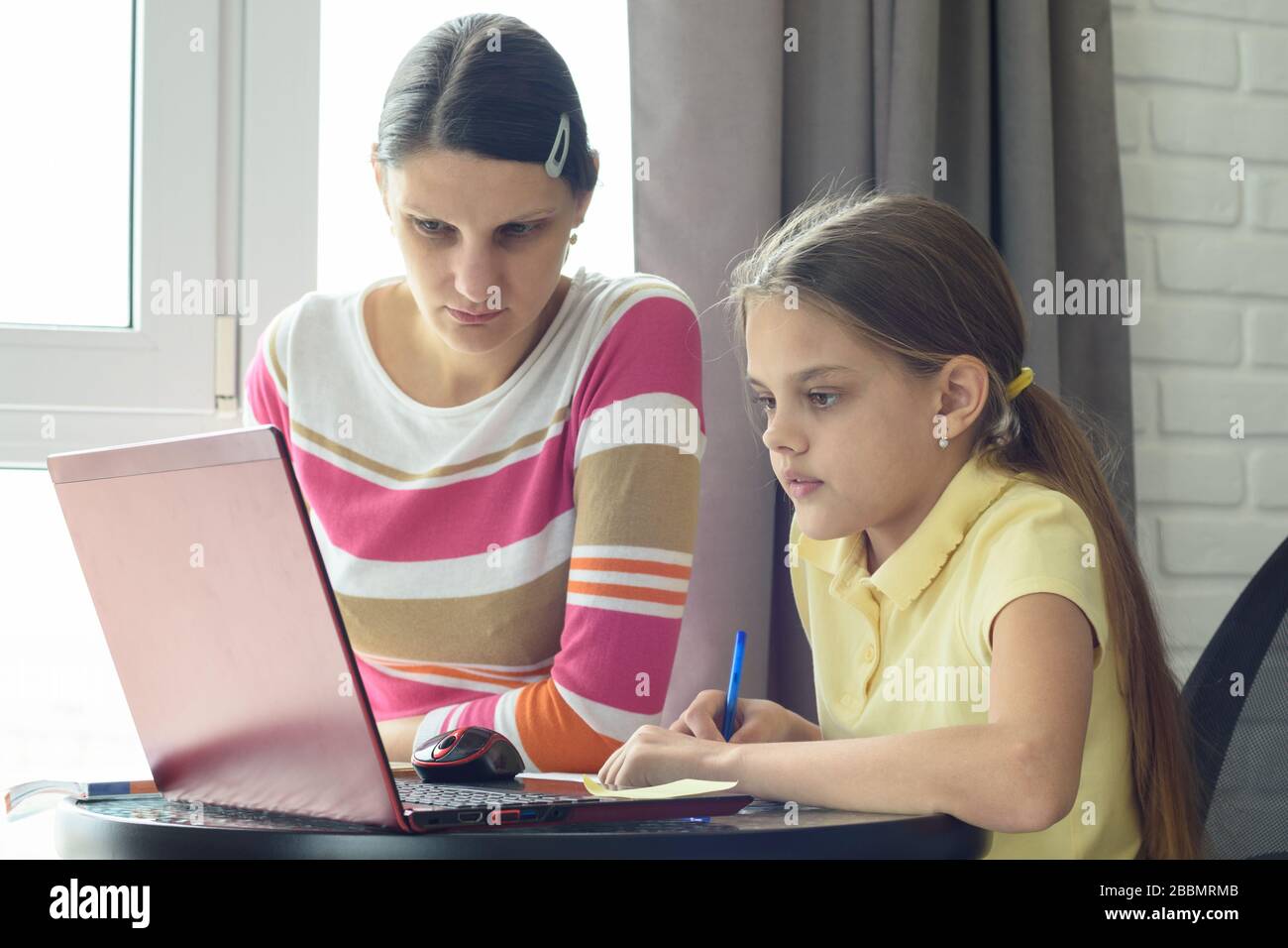 Mom and daughter solve homework using online distance learning Stock ...