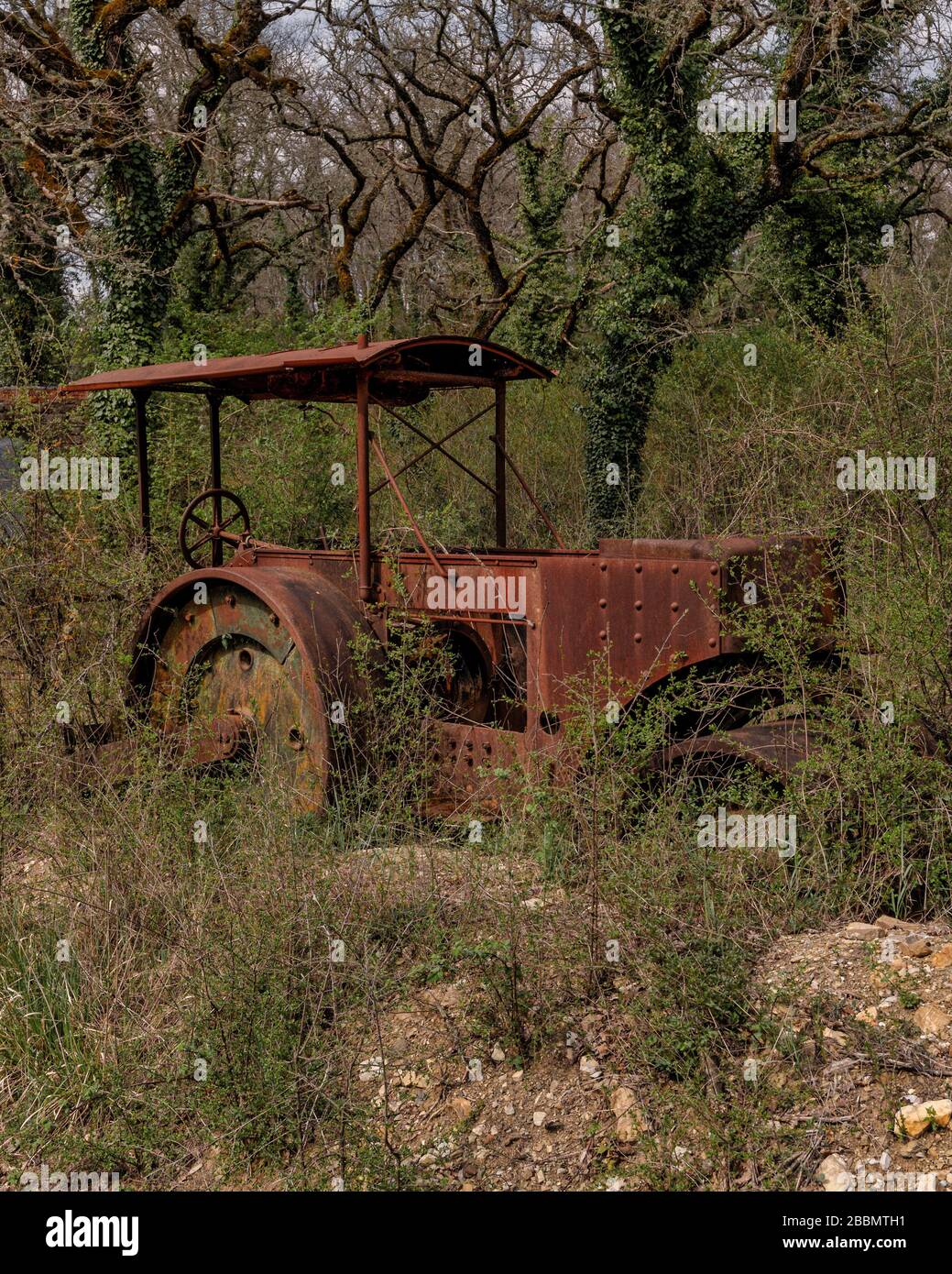 An old abandoned rusty derelict tractor parked in a farm yard in ...