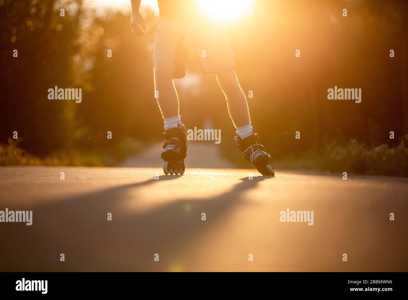 Man roller skating on the cycle path during lovely summer sunset, sport ...
