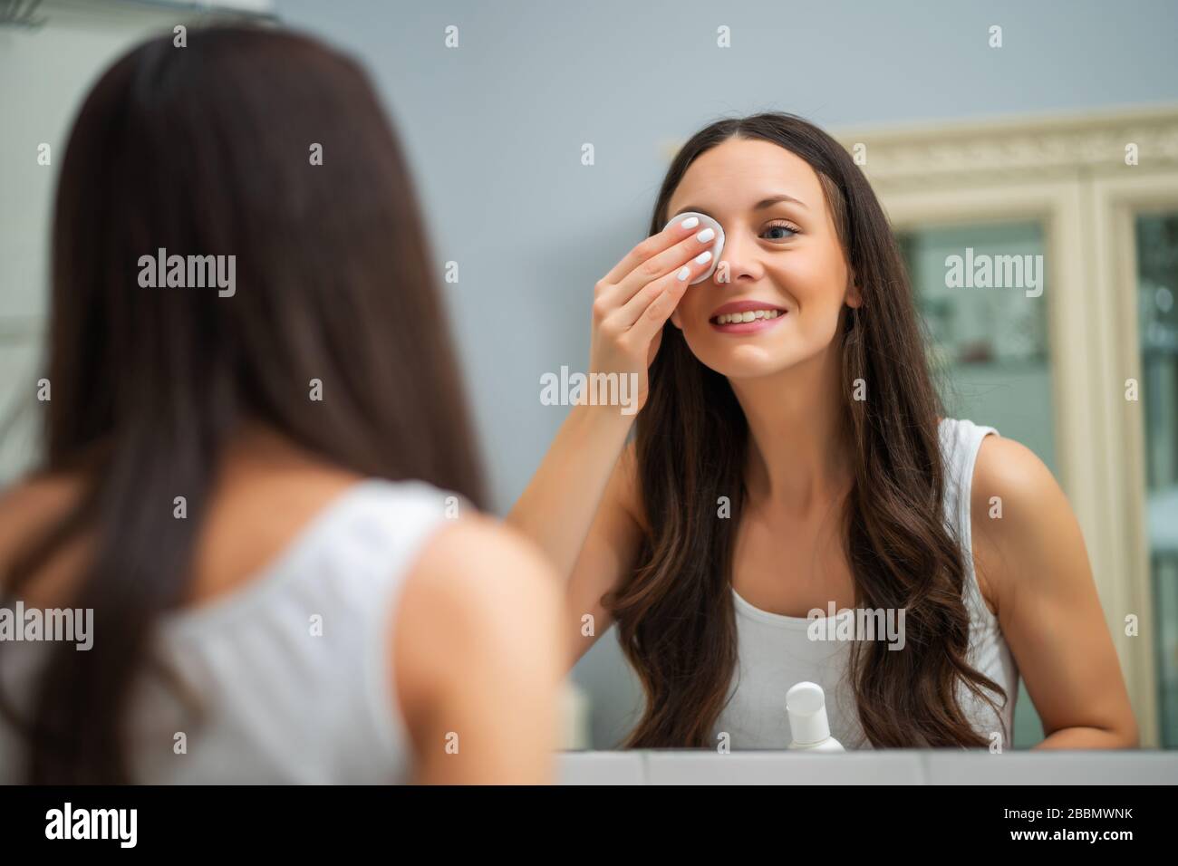 Portrait of young woman who is cleaning skin on her face Stock Photo ...