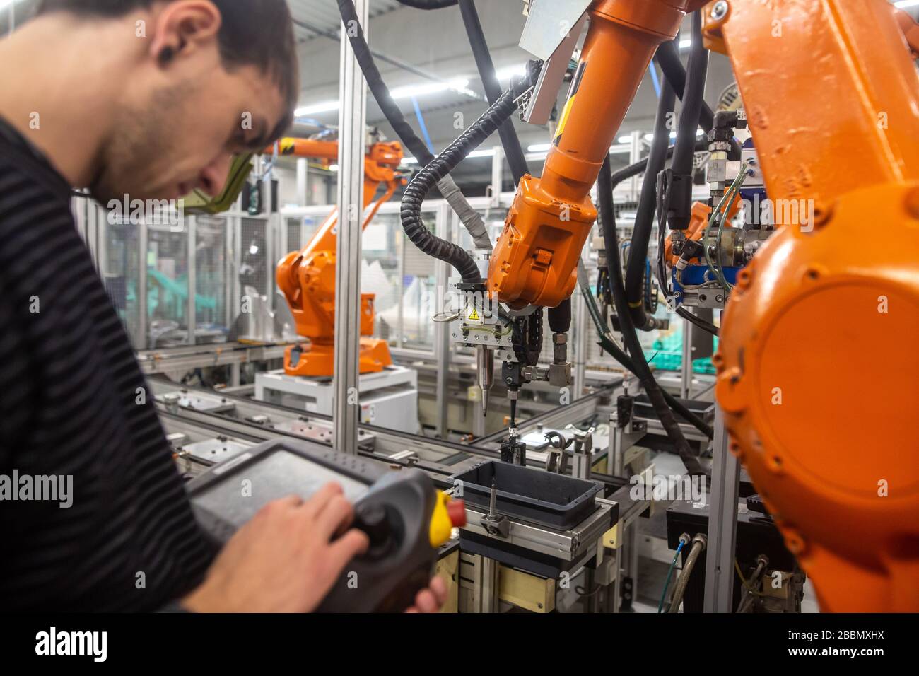 Man programming robot in automotive industrial, professional programmer ...