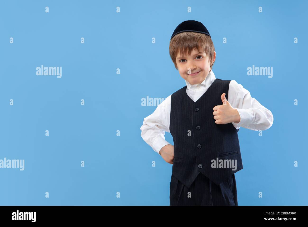 Thumb up. Portrait of a young orthodox jewish boy isolated on blue ...