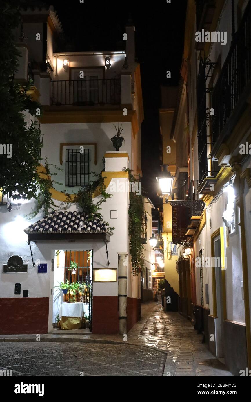 Spanish street scene. View up a traditional narrow side street lit up ...