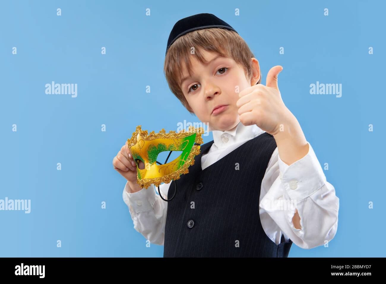 Trying carnival mask on. Portrait of a young orthodox jewish boy ...