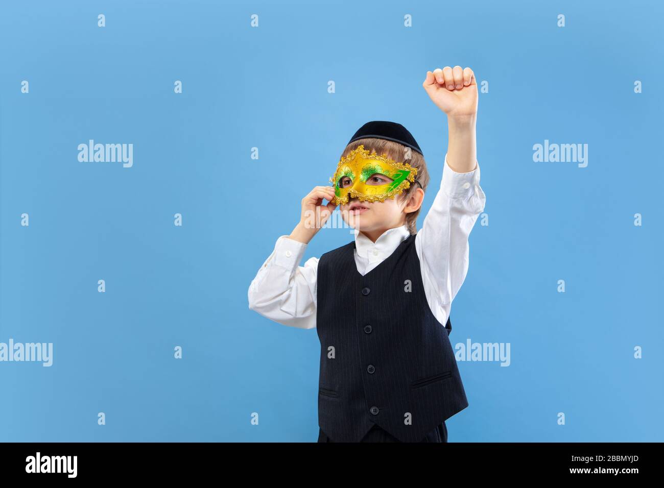 Trying carnival mask on. Portrait of a young orthodox jewish boy ...