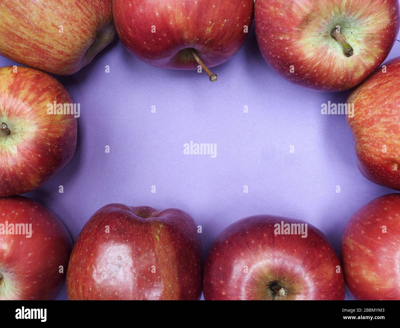 Top view of red apples on plain purple background Stock Photo - Alamy