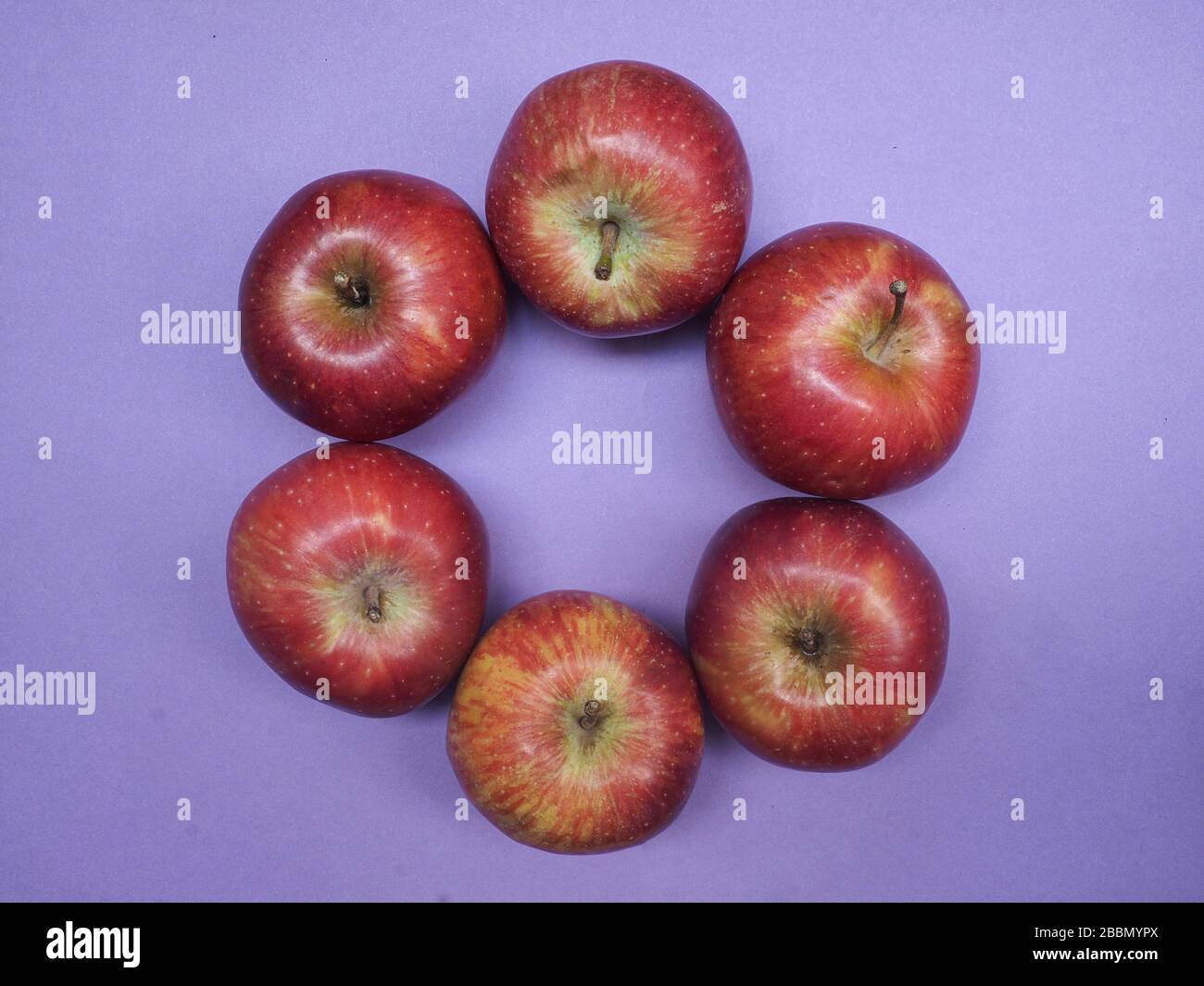 Top view of red apples on plain purple background Stock Photo - Alamy