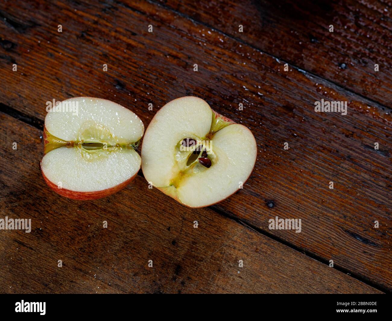 Top view of red apple cut in half on table Stock Photo - Alamy