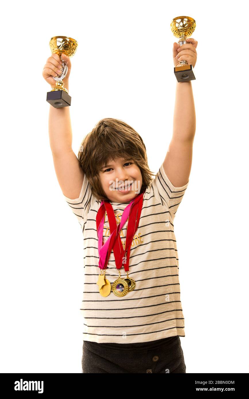 Victorious boy with medals raising his hand with trophies isolated on ...