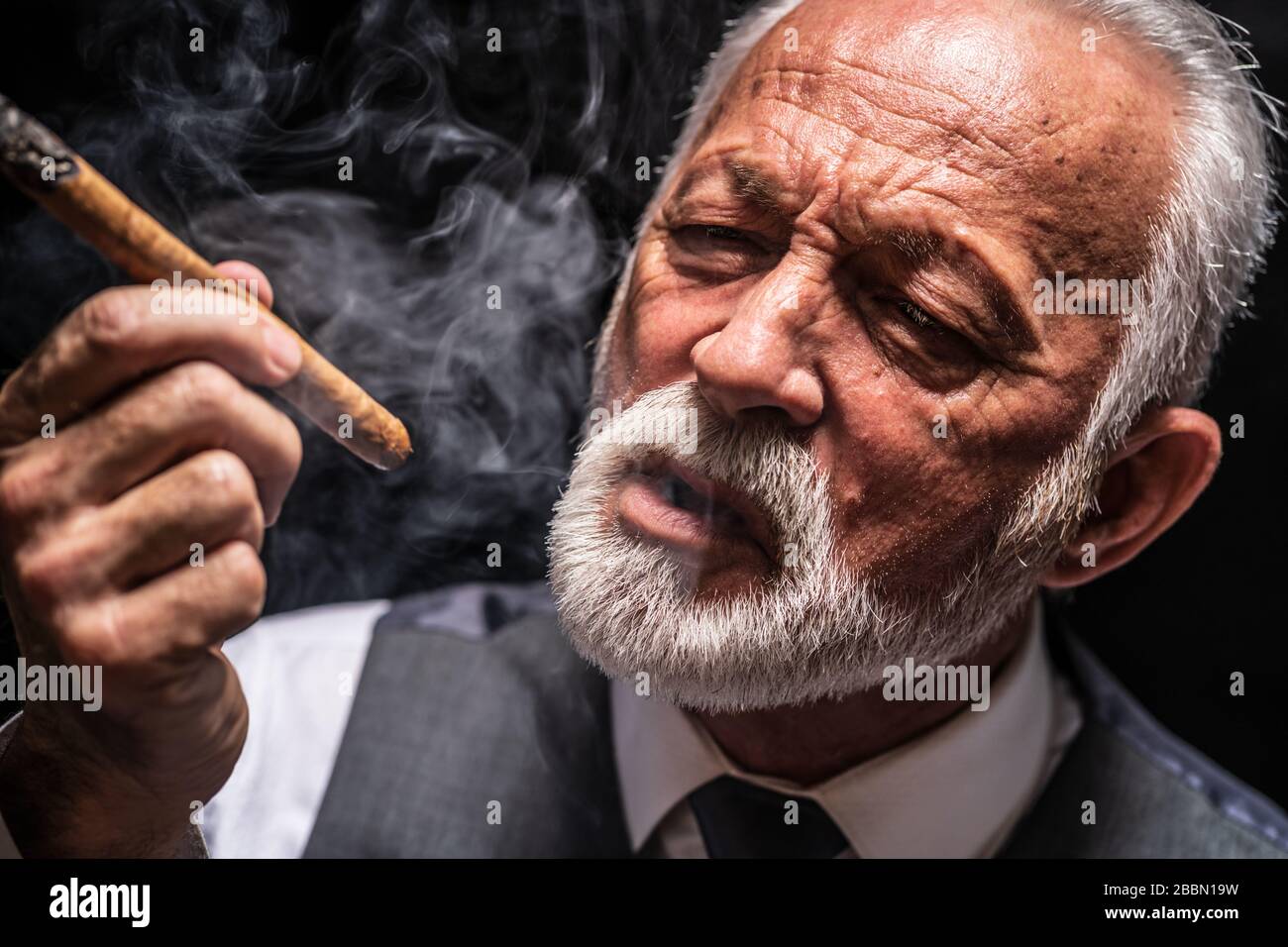 Mature businessman smoking cigar hi-res stock photography and images - Alamy