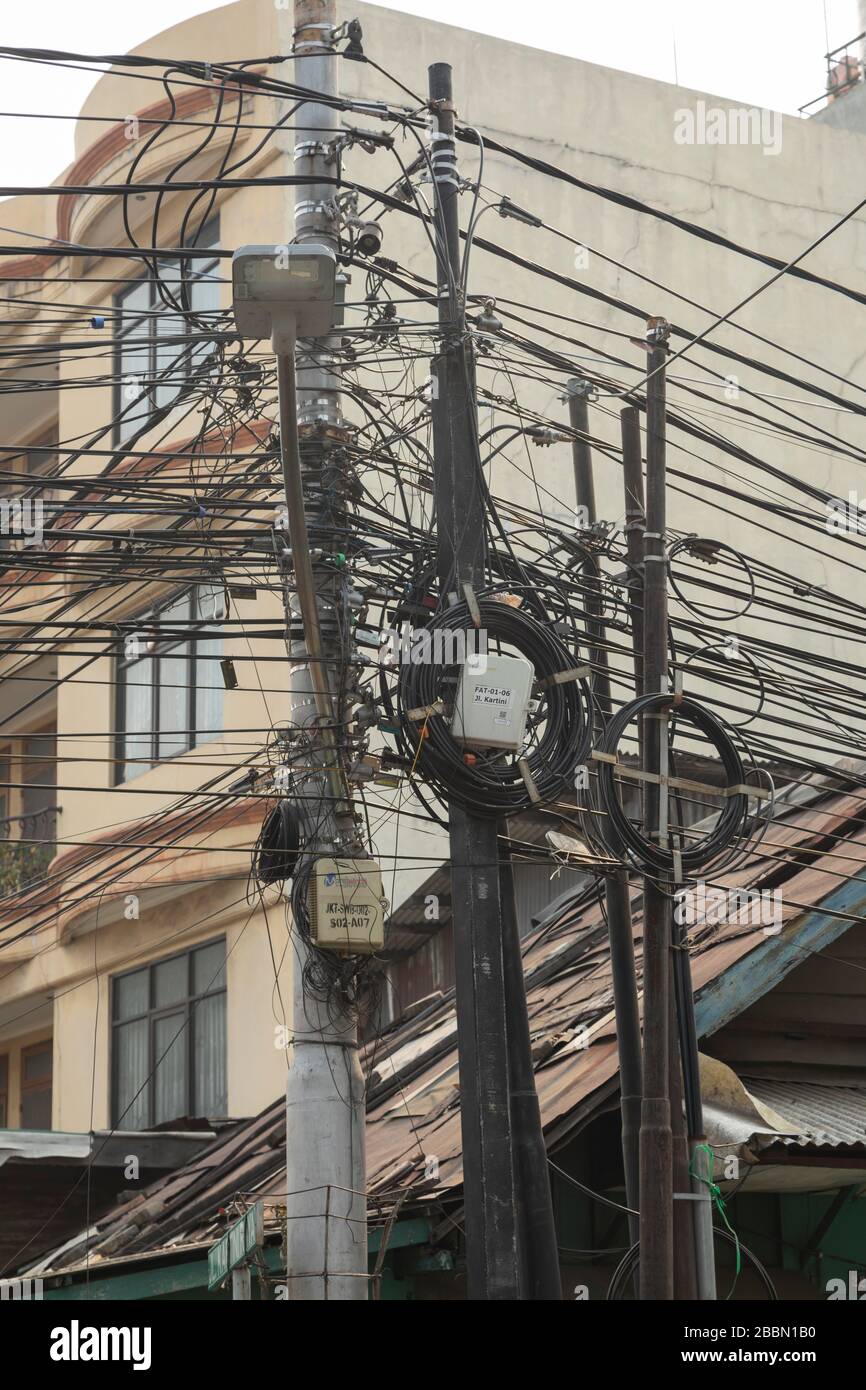 Jakarta, Indonesia - July 13, 2019: Poles loaded with a tangle of black ...