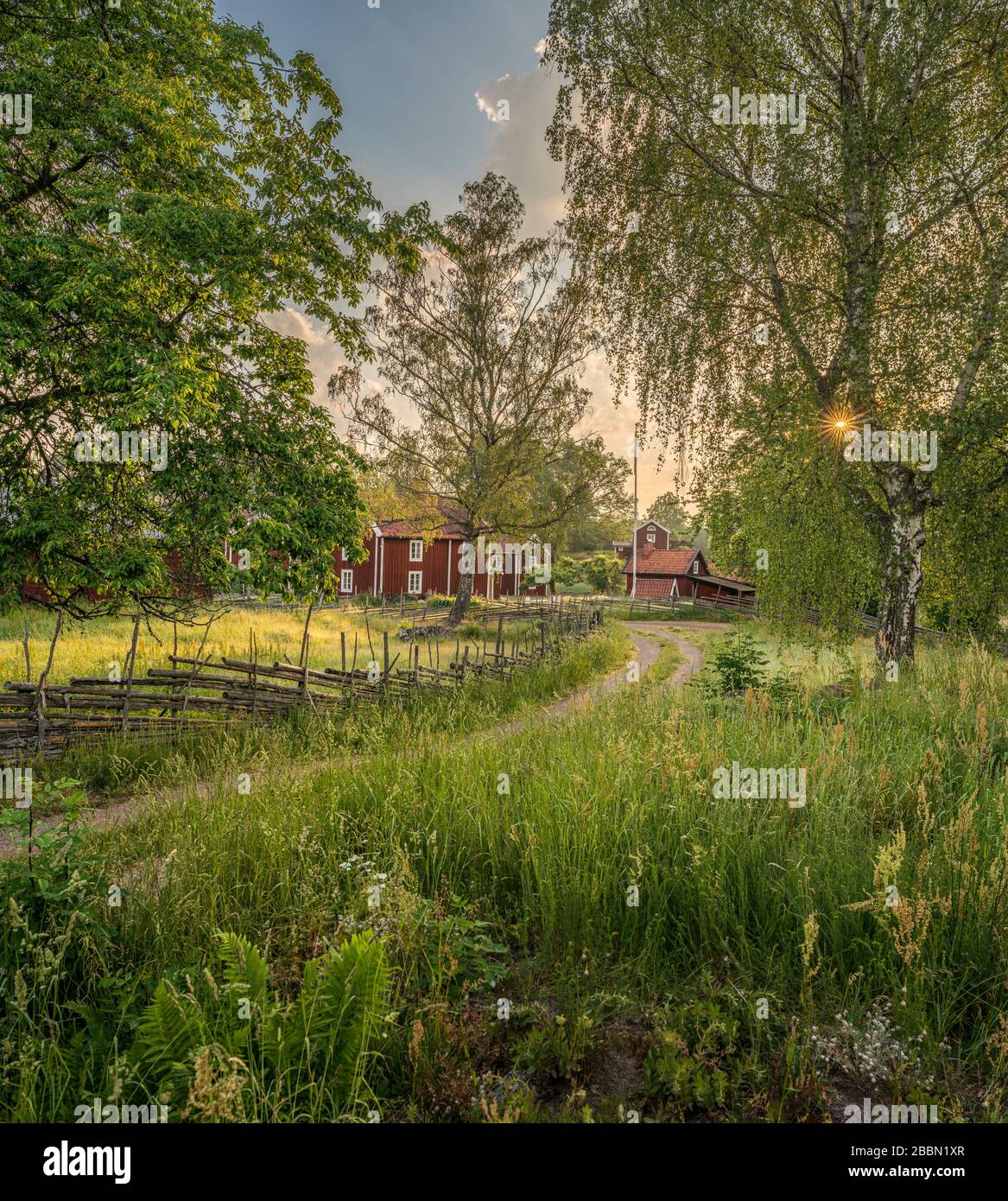 Small country road and old traditional red cottages in a rural ...