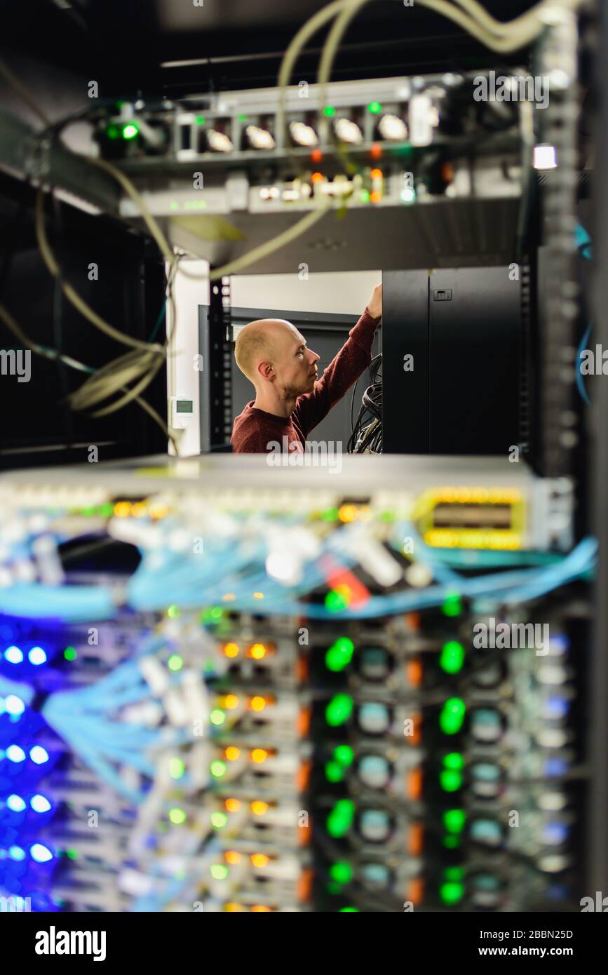 Man data center technician performing server maintenance. Replacing ...