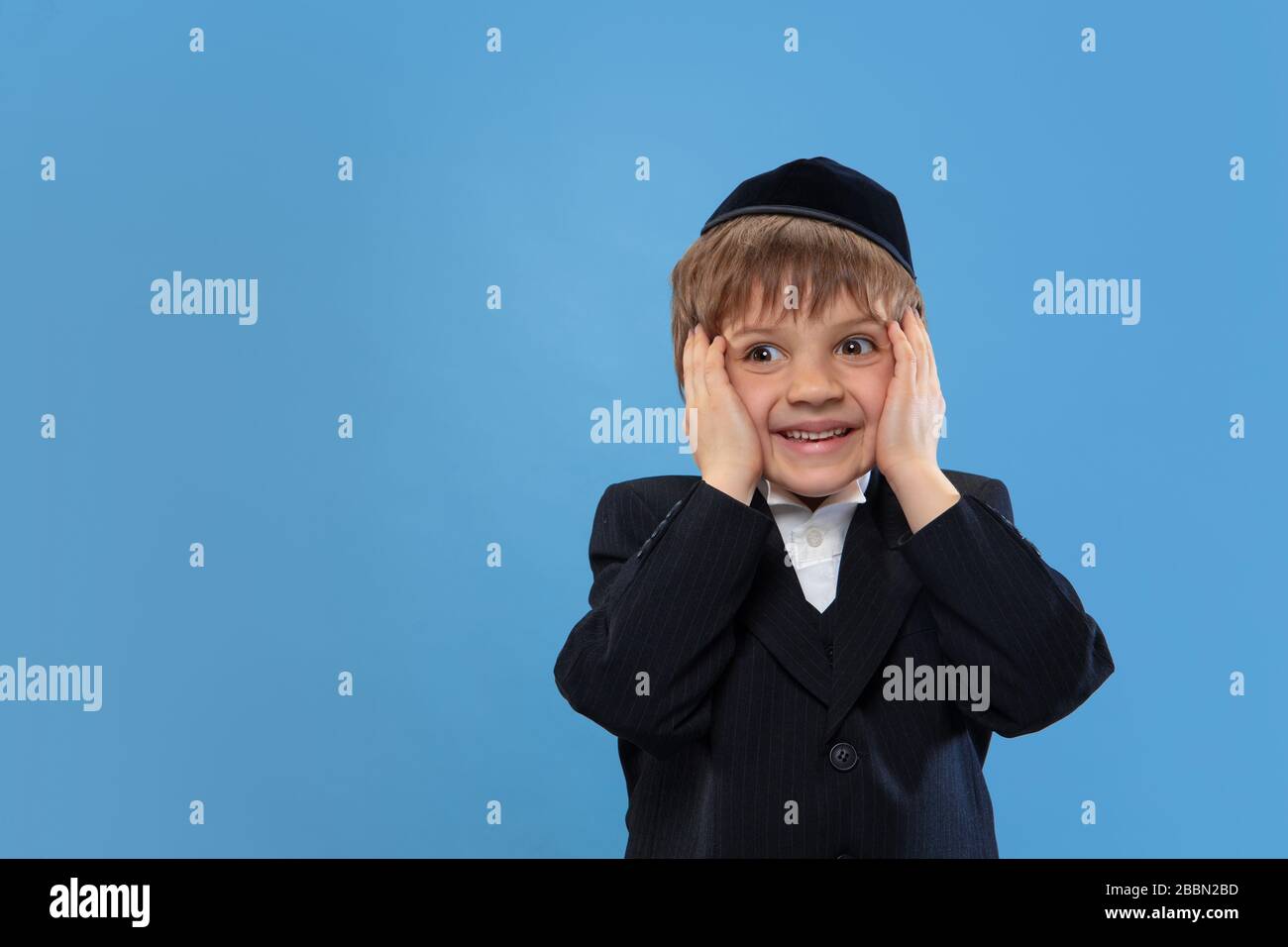Astonished. Portrait of a young orthodox jewish boy isolated on blue ...