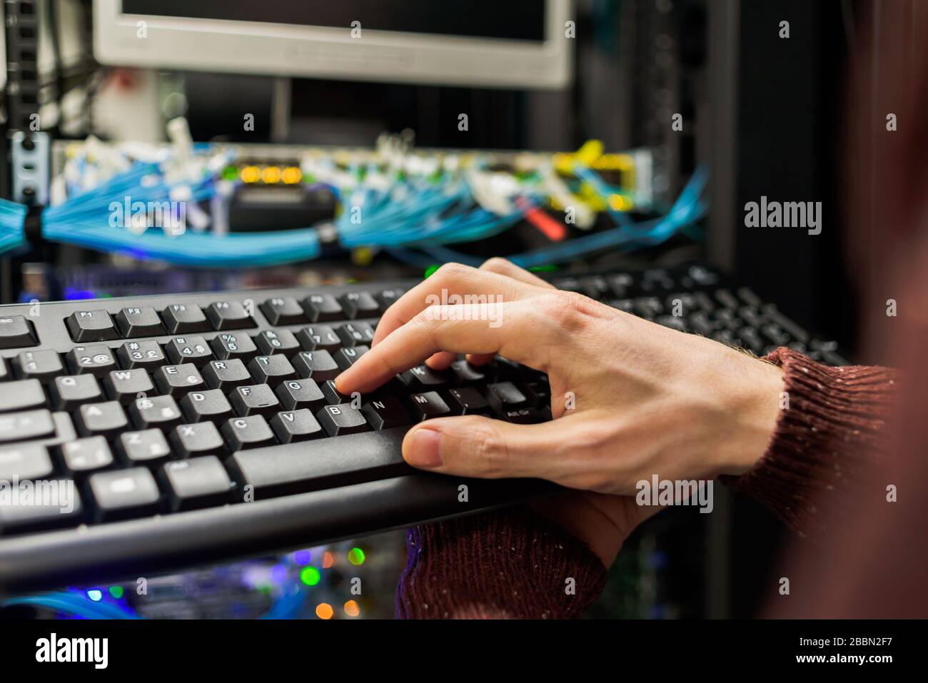 Man Data Center Technician Performing Server Maintenance Using Keyboard To Configure