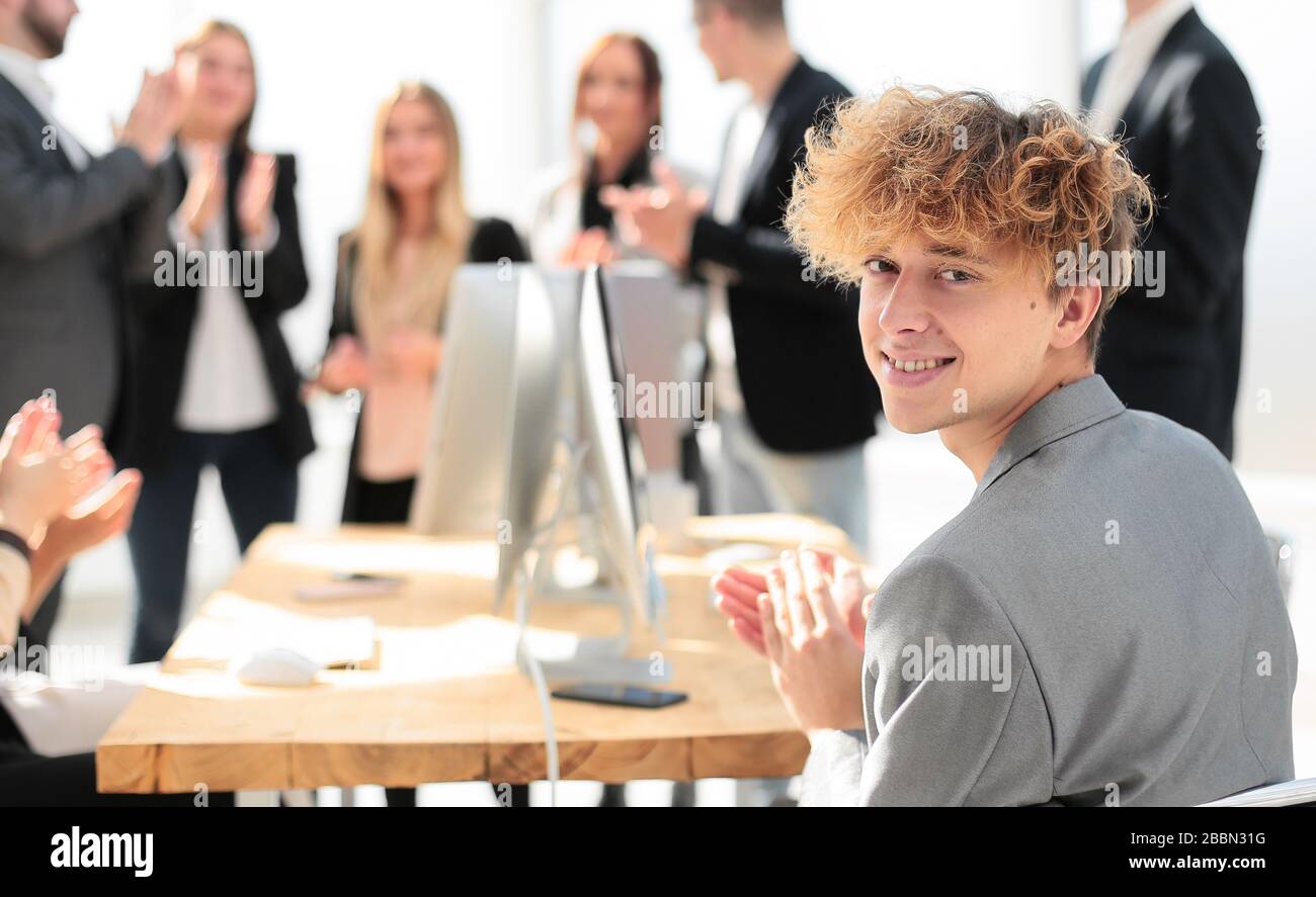 young employee applauds sitting at the office Desk Stock Photo - Alamy
