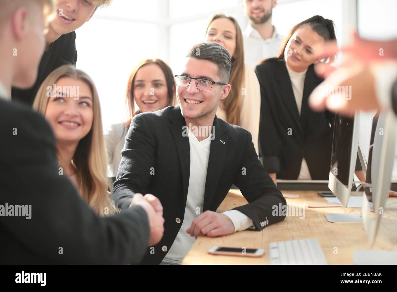 Manager congratulating a young employee in the workplace Stock Photo ...