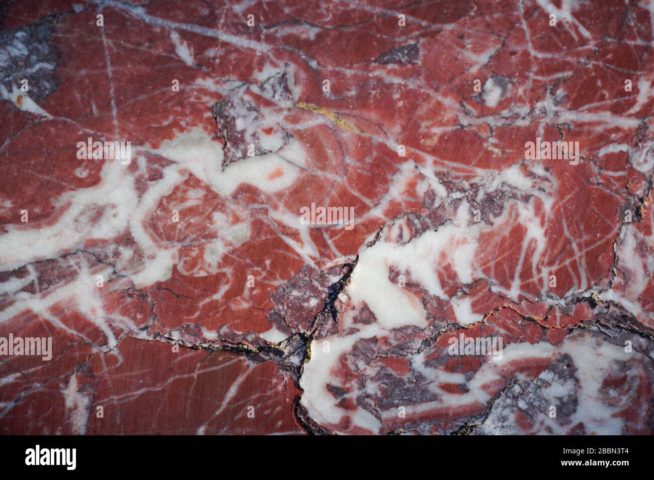 Close-up of cracked natural red marble stone. Red marble stone with ...
