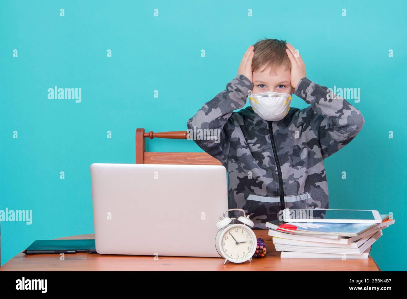 Kid with mask in quarantine working and learning from home Stock Photo ...