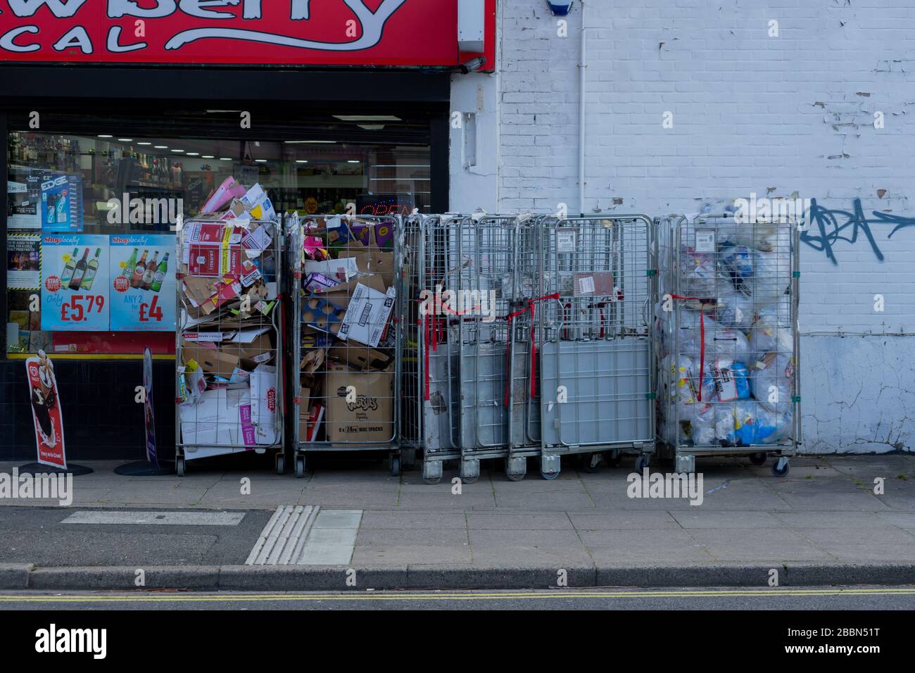 Metal cages outside a corner shop full of rubbish, trash or recycling ...