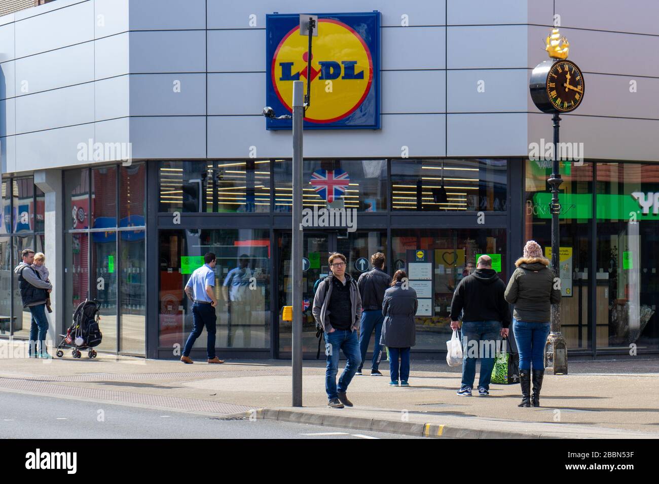 Shopper queuing outside a Lidl supermarket standing two meters apart ...