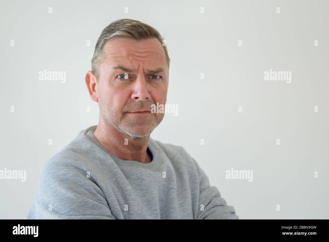 Half-turn bust portrait of middle-aged man in grey pullover, looking at ...