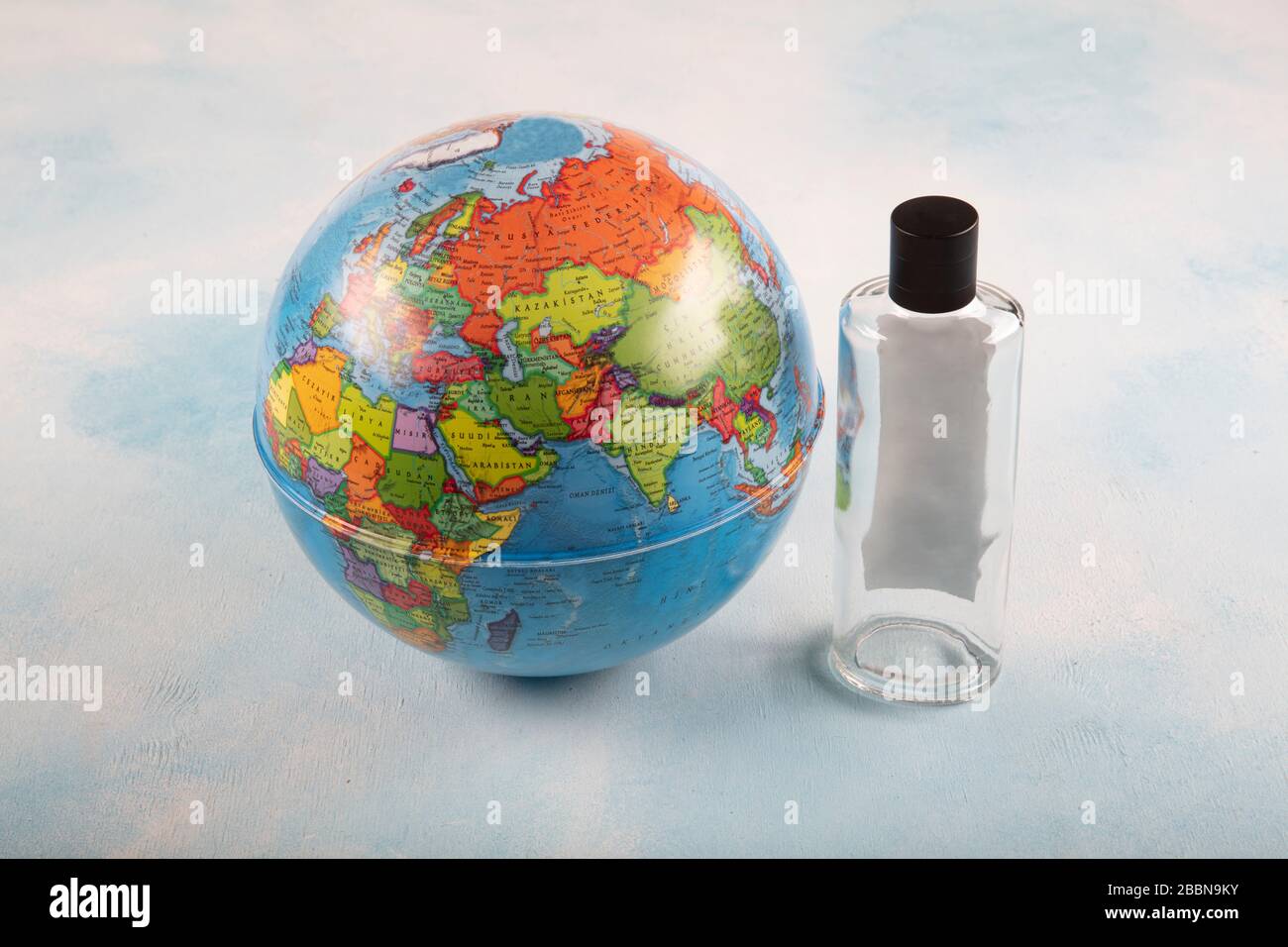 cologne for the world. Globe and cologne ( kolonya ) isolated on blue ...