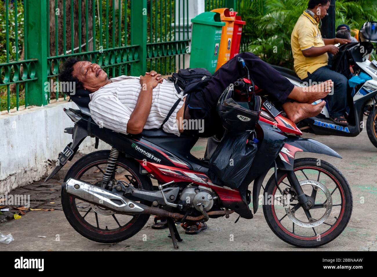 A Man Laying On His Motorcycle Asleep, Jakarta, Indonesia Stock Photo ...