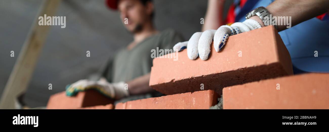 Builders make wall brick and cement, technology Stock Photo - Alamy
